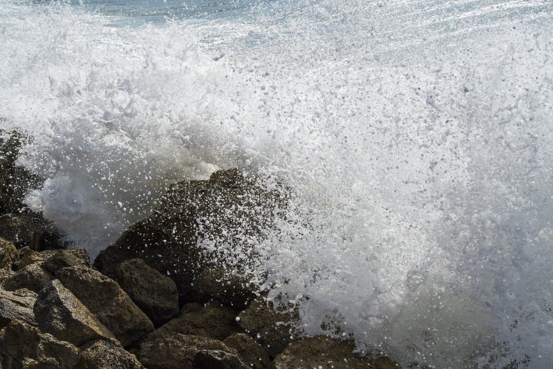 A Wave Breaking on Rocks stock image. Image of coast - 258494003