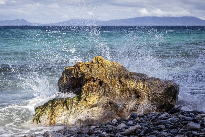A Wave Breaking into Spray on a Large Stone! Stock Photo - Image of ...