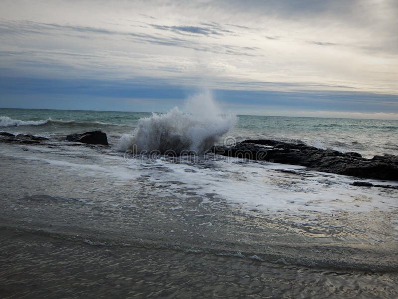 Wave breaks on the rocks stock photo. Image of gale - 160994968