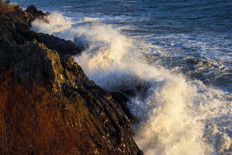 A Wave Breaks on the Rocks at Sunset Stock Photo - Image of breaks ...