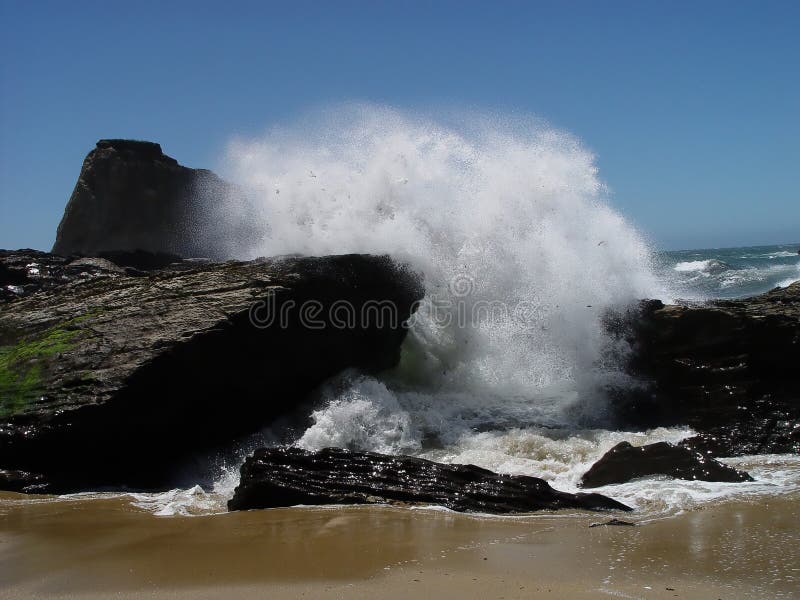 Wave Crashing Over Rocks on Sandy Beach Blue Sky Stock Photo - Image of ...