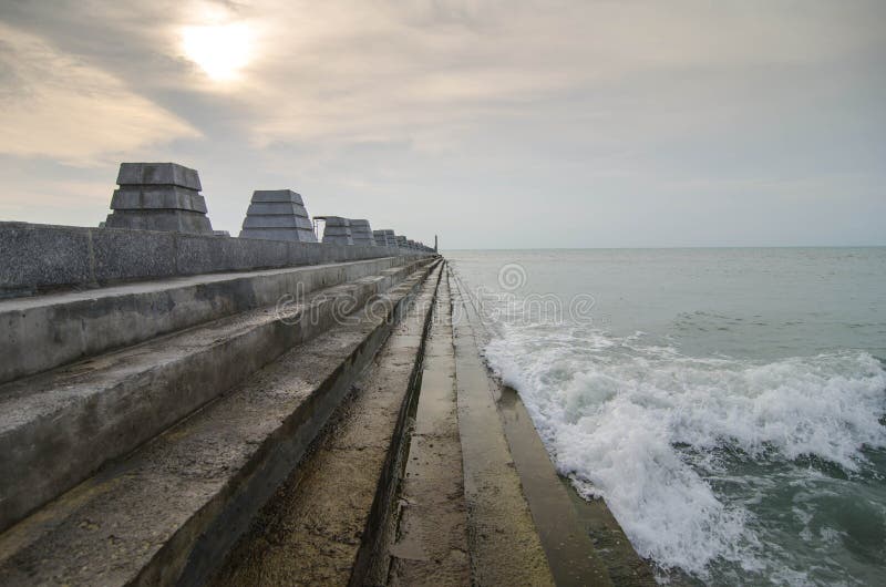 Wave Hitting Concrete Jetty or Pier on the Beach Over Sunset Stock ...