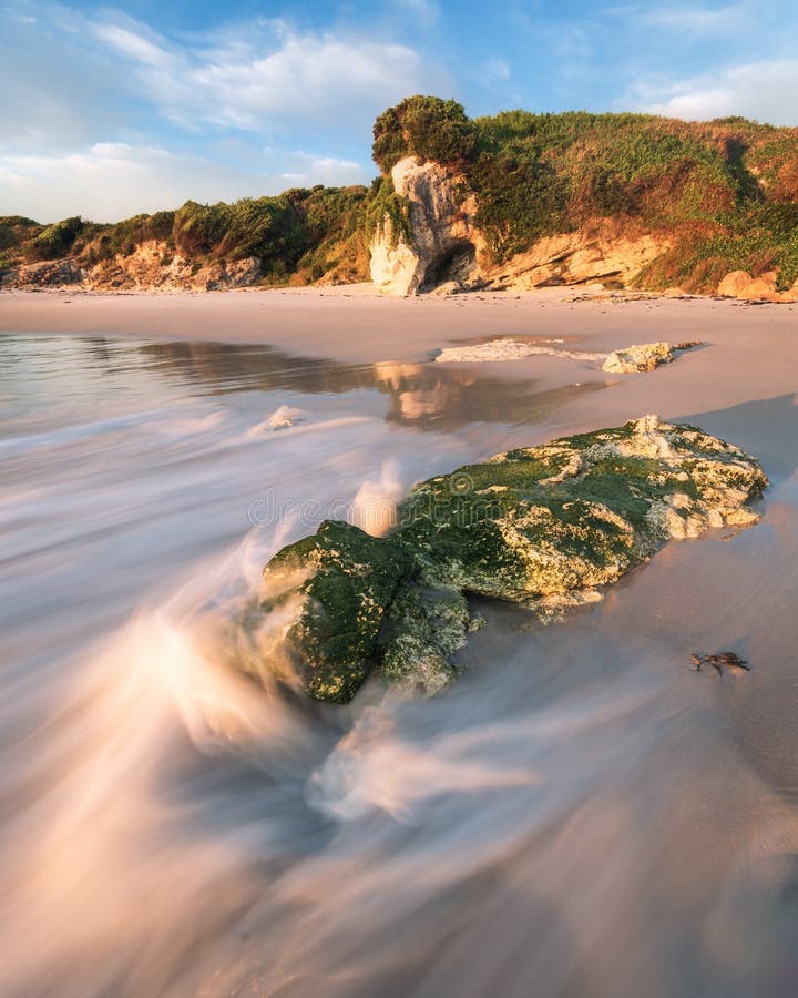 Wave on a Mossy Rock and Sandy Beach on Broughton Island in Australia ...