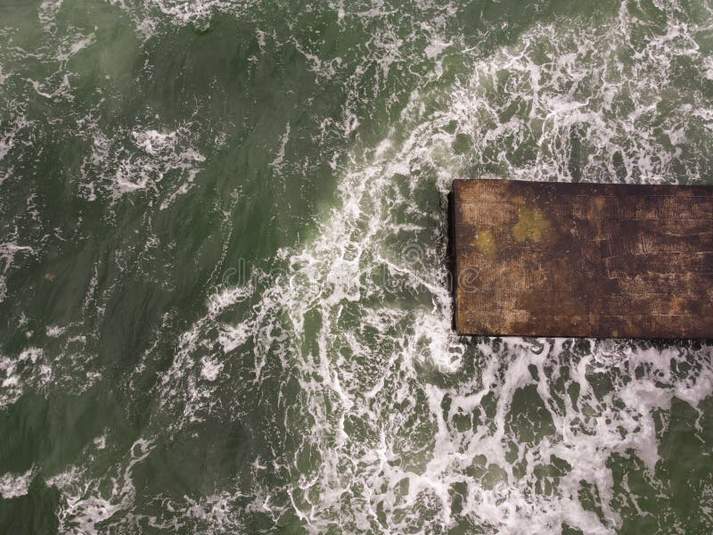 The Wave Rolls Over a Large Square Rock Lying on the Shore, Covered ...