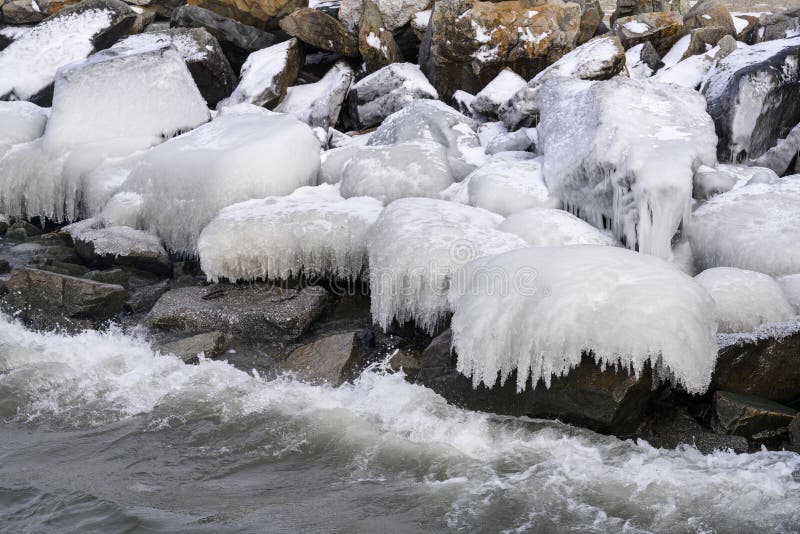 A Wave Runs Over Coastal Rocks in the Cold, Covering Them with Ice and ...