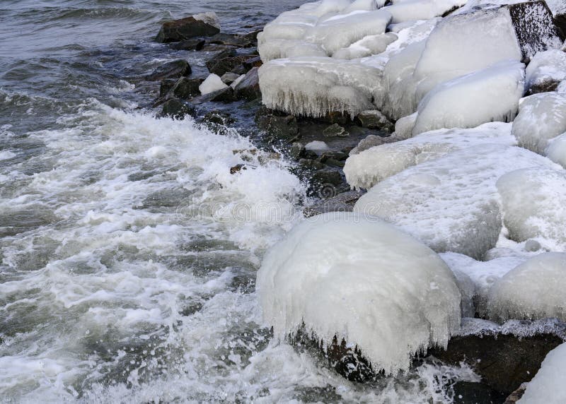 A Wave Runs Over Coastal Rocks in the Cold, Covering Them with Ice and ...