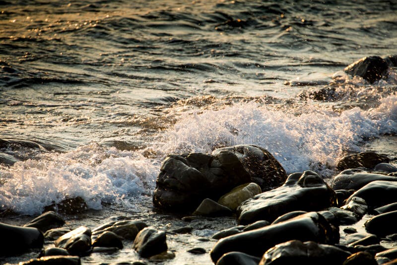 Wave splashing over rocks stock photo. Image of seascape - 80240650