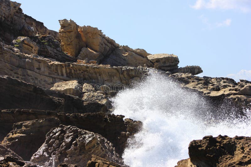 Waves against the cliff stock photo. Image of crash - 194857616