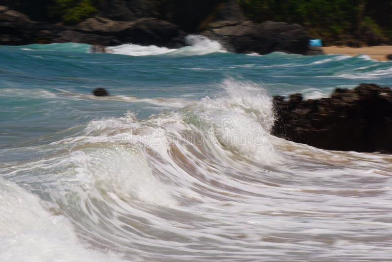 Waves Breaking Onto Rocks with a Blue Ocean Behind Them Stock Photo ...