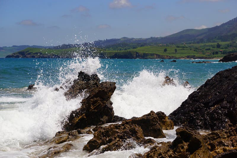 Waves Breaking Onto Rocks with a Blue Ocean Behind Them Stock Photo ...