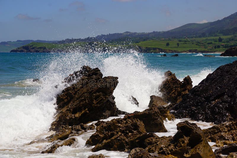 Waves Breaking Onto Rocks with a Blue Ocean Behind Them Stock Photo ...