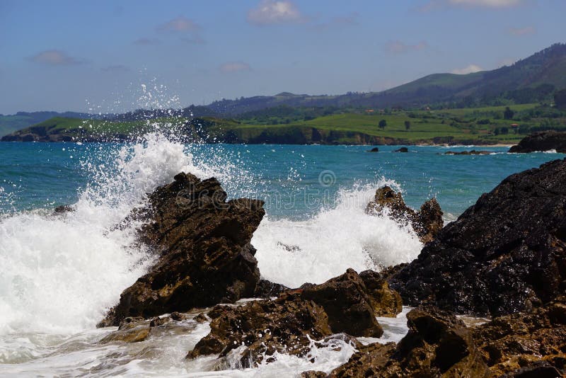 Waves Breaking Onto Rocks with a Blue Ocean Behind Them Stock Photo ...