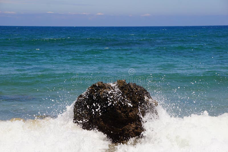 Waves Breaking Onto Rocks with a Blue Ocean Behind Them Stock Photo ...