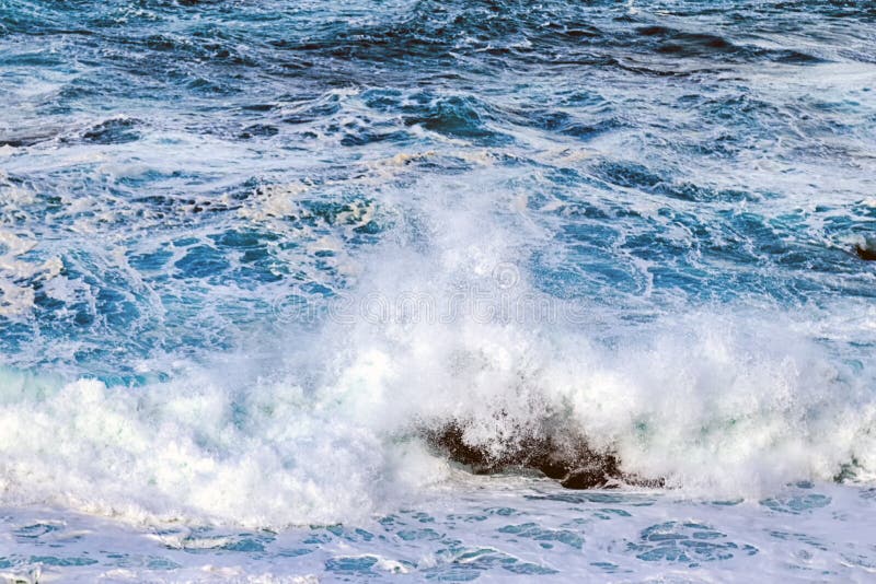 Waves breaking at a rock stock photo. Image of waves - 168350034