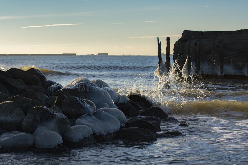 Waves crahing on icy rocks stock image. Image of blue - 252741579
