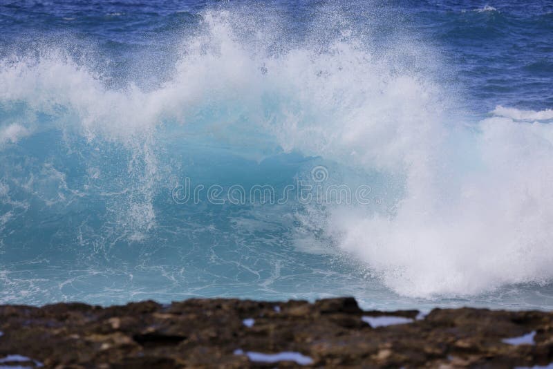 Waves Crashing with Blurry Rocks in the Foreground Stock Image - Image ...