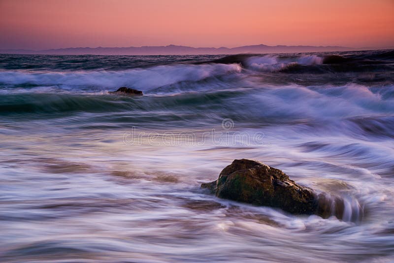 Waves Crashing Over a Rock at Sunset Stock Image - Image of rock ...