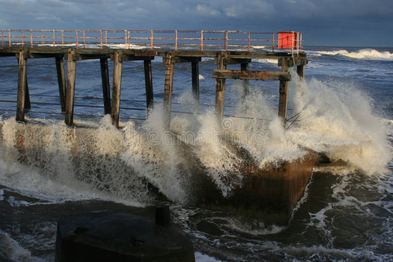 Waves crashing into pier stock image. Image of england - 15338531