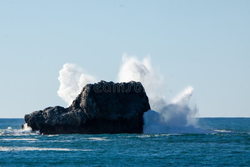 Waves crashing into a rock stock photo. Image of splash - 336919956