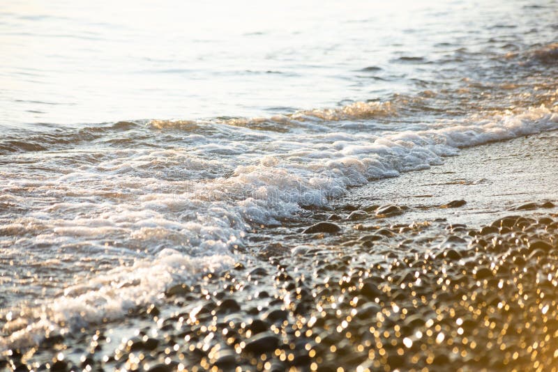 Waves with Foam in Bright Sunlight on a Pebble Beach Stock Photo ...