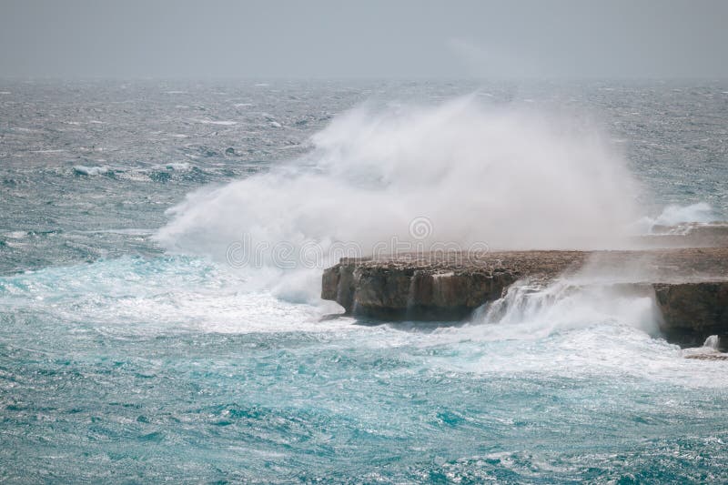 The Waves Hit the Rocks with Great Splashes. Rocky Seashore with Blue ...