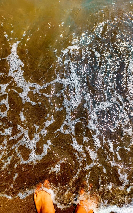The waves hitting the feet stock image. Image of freezing - 224217511