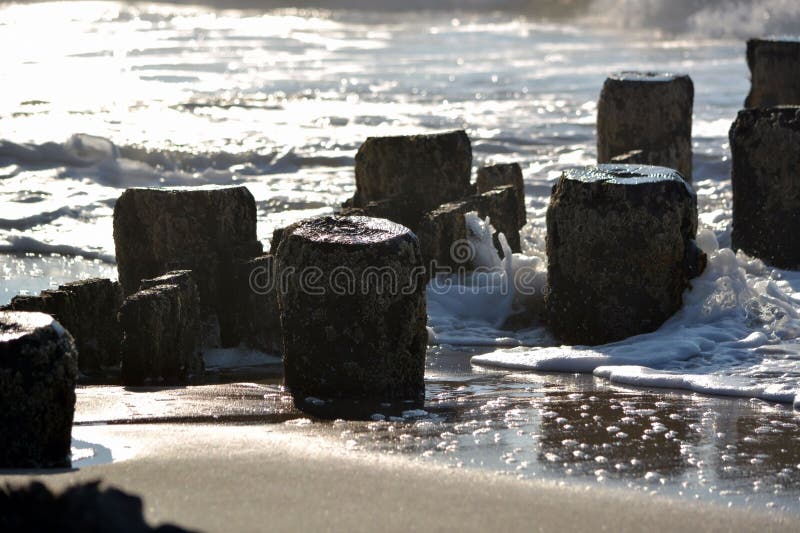Waves Splashing into Wooden Pilings on the Beach Stock Image - Image of ...