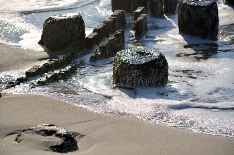 Waves Splashing into Wooden Pilings on the Beach Stock Photo - Image of ...