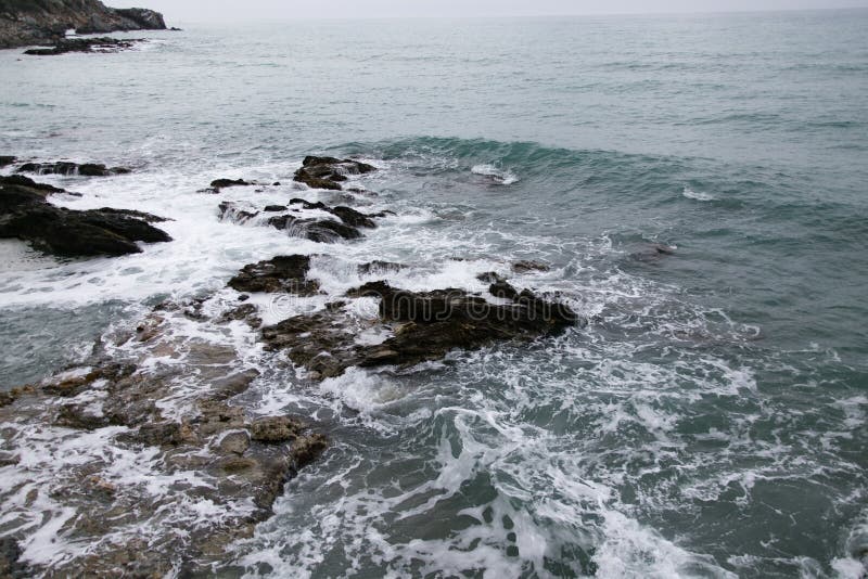 Waves washing rocks stock image. Image of enormous, power - 89414975