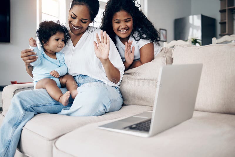 Waving Hello from the Sofa. a Young Mother Using a Laptop with Her Daughters on the Sofa. Stock ...