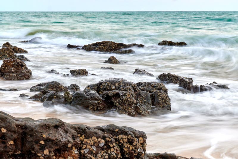 Wavy Sea with Rocks Near a Beach Stock Photo - Image of ocean, blue ...