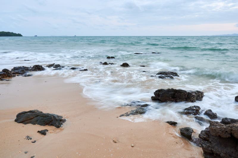 Wavy Sea with Rocks Near a Beach Stock Photo - Image of sandy ...