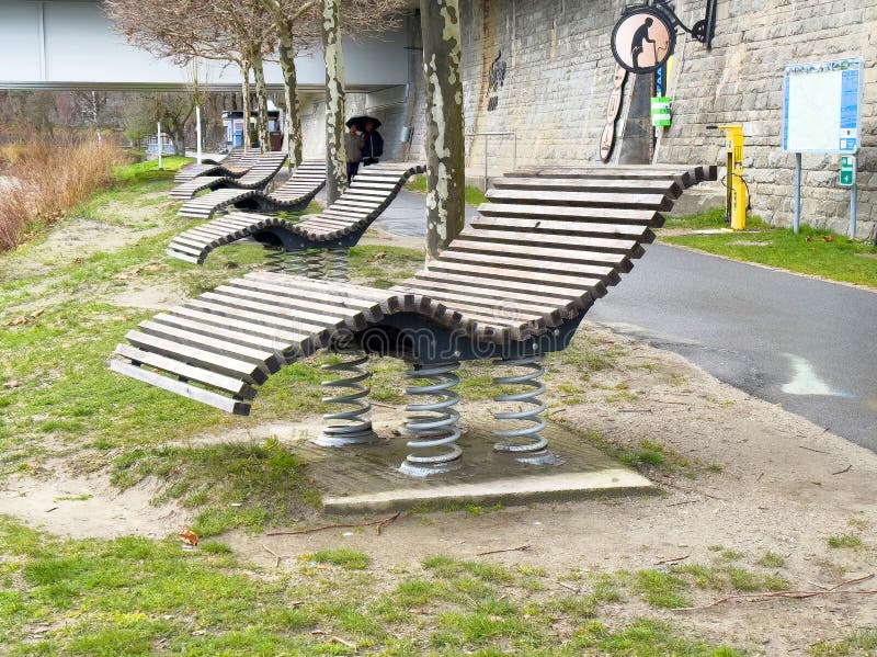 Wavy Wooden Benches with Spring Supports in Park Setting by Stone Wall ...