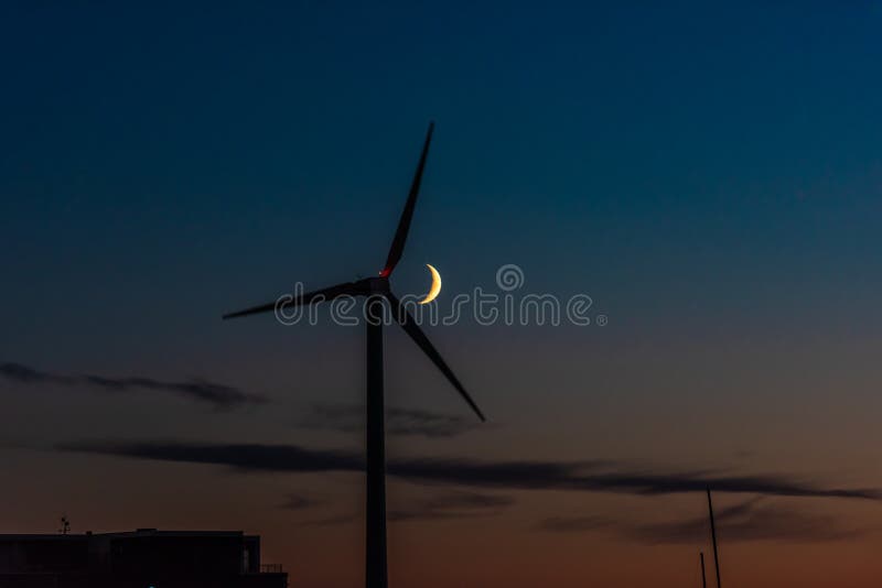 Waxing Crescent Moon Passing Behind a Wind Turbine at Night Stock Photo ...