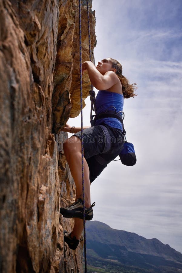On the Way Up the Mountain. Side View of a Young Woman Rock Climbing ...