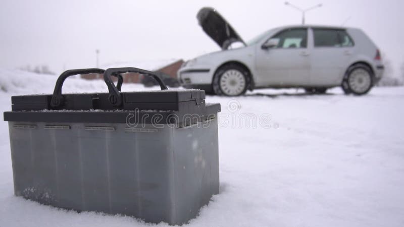 Weak Car Battery in the Background of the Car with an Open Hood, Winter ...