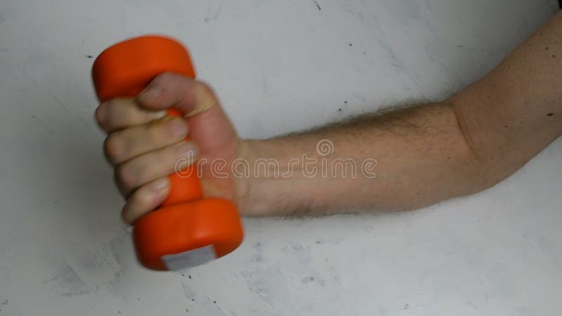 Weak, without Muscles Male Arm Does an Exercise with a Orange Dumbbell ...