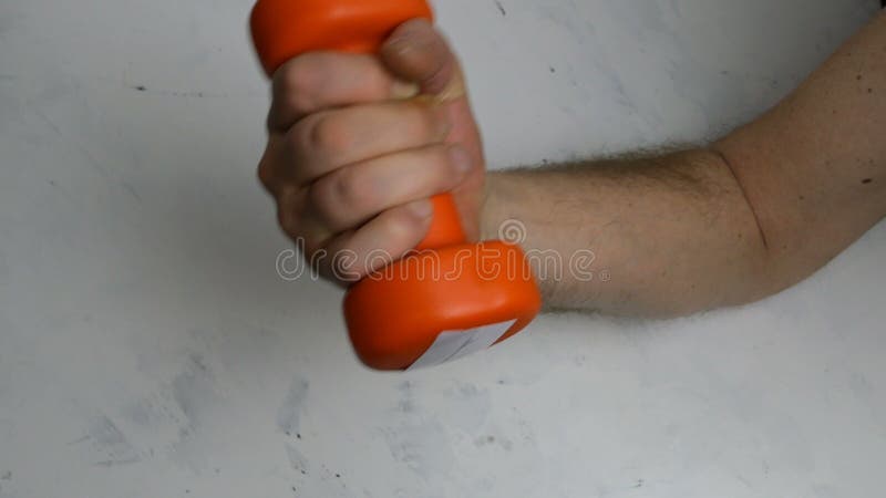 Weak, without Muscles Male Arm Does an Exercise with a Orange Dumbbell ...