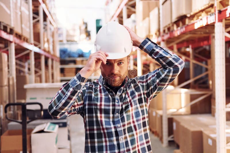 Wearing Hard Hat. Employee in Uniform is Working in the Storage at ...