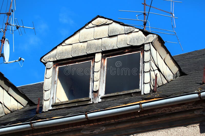 Weathered Attic Dormer Windows with Antennas on a Tiled Rooftop Under ...