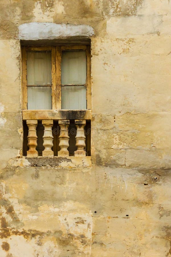 Weathered Building Facade with Rustic Window and Ornate Stucco Details ...
