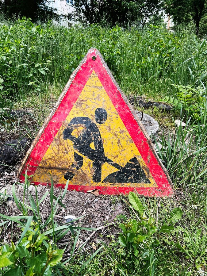Weathered Construction Sign Placed in a Grassy Area Under Bright ...
