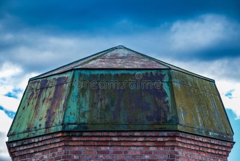 Weathered Copper Roof on a Brick Structure Under a Dramatic Cloudy Sky ...