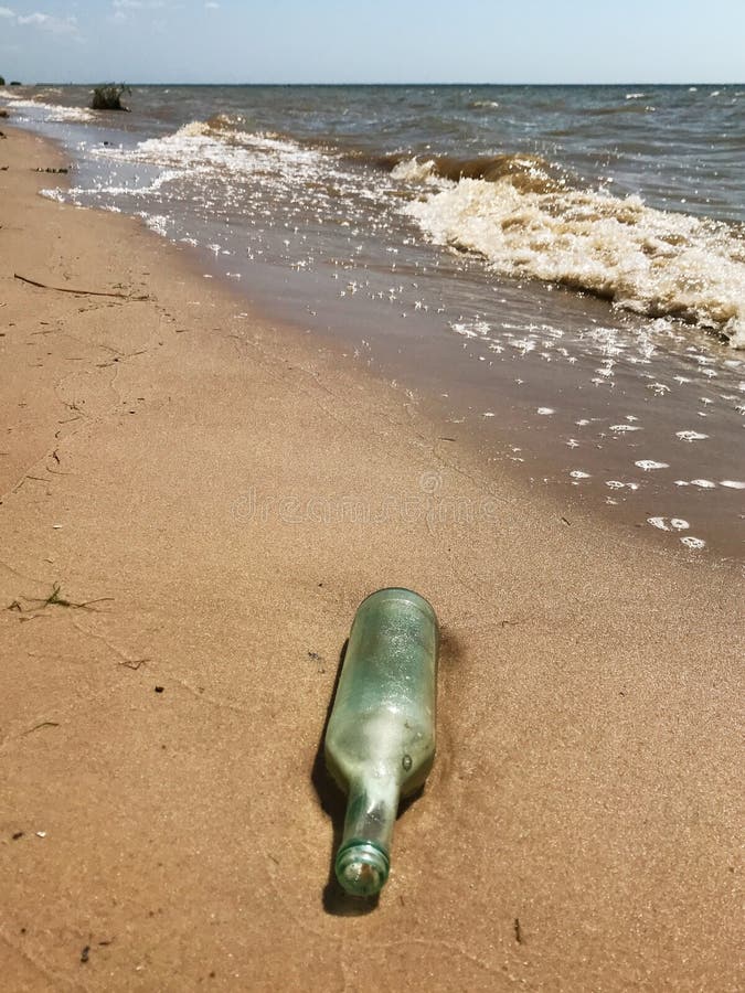 Weathered Glass Bottle Washed Ashore on a Sandy Beach Stock Image ...