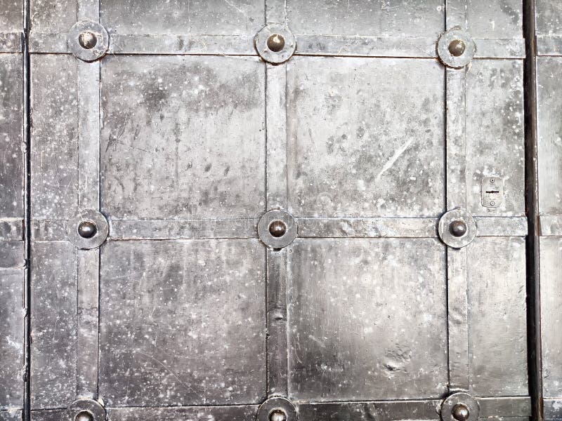 A Weathered Metal Door Showcases Riveted Panels, Reflecting the Charm ...