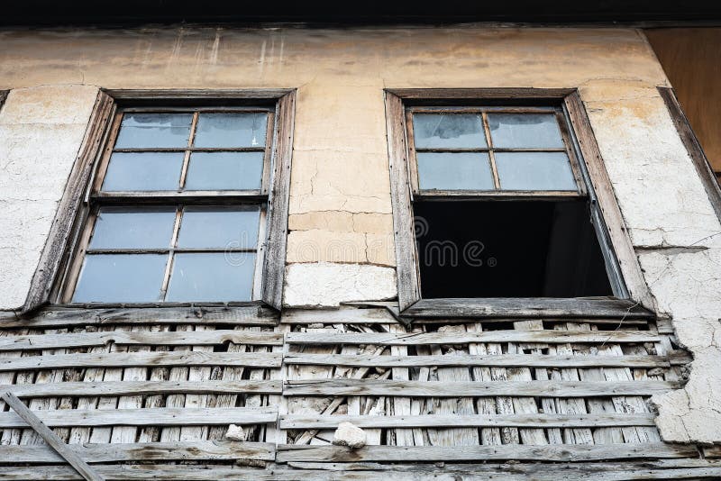 Weathered Old Building with Broken Windows and Worn Wooden Lattice on ...