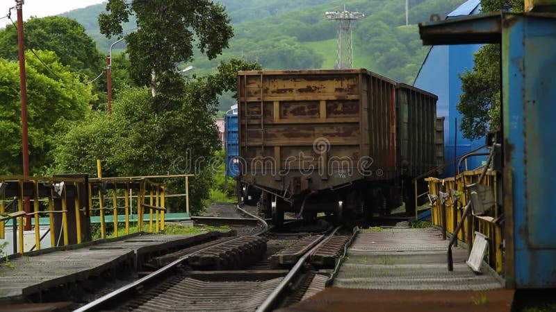 An Old Rustic Train Car Placed on Industrial Tracks Surrounded by ...