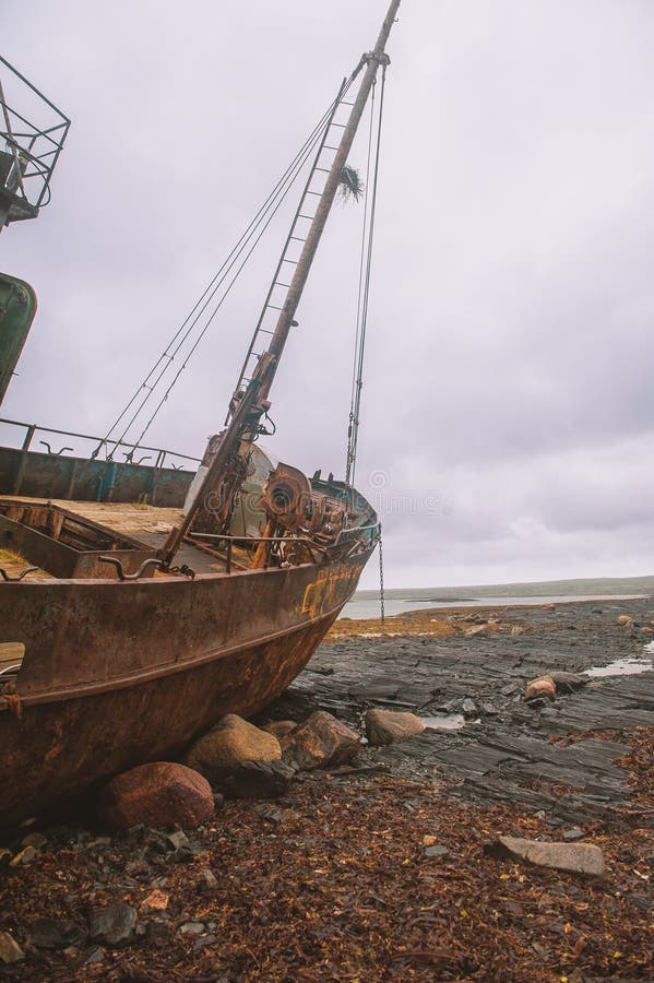 Weathered Vessel Stranded on a Rocky Beach, Showcasing Nautical History ...