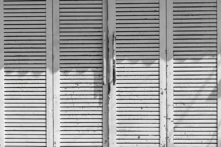 Weathered White Wooden Shutter Doors with Vertical Slats and Shadow ...