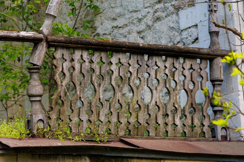 Weathered Wooden Railing with Intricate Patterns and Overgrown Greenery ...